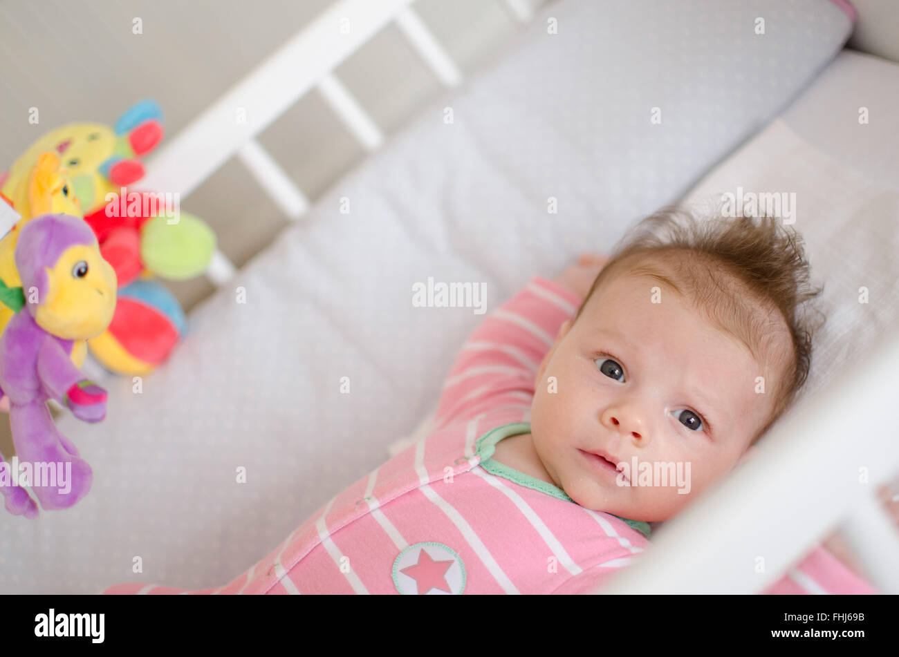 little cute baby girl playing in a cot Stock Photo - Alamy
