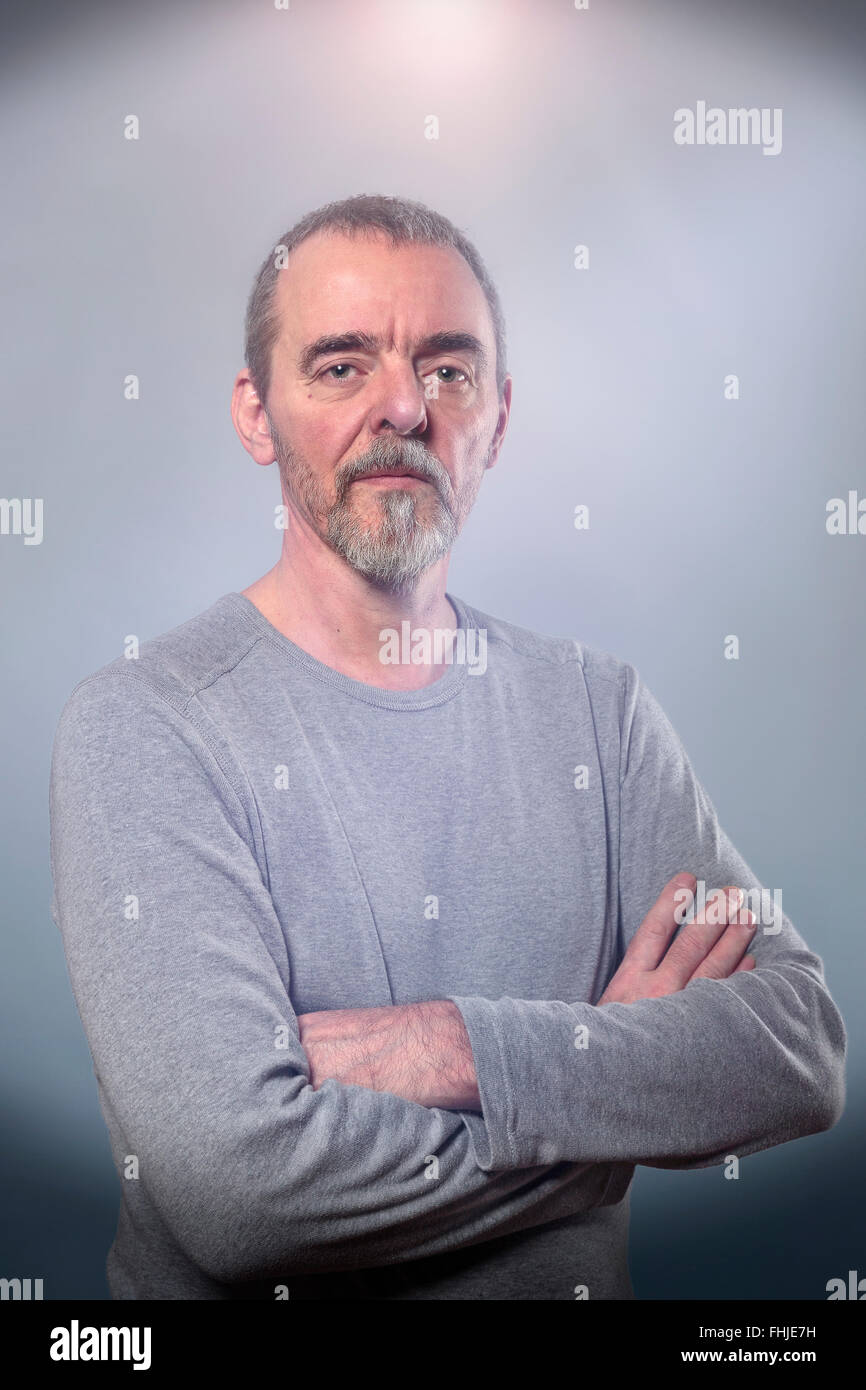 Portrait of a smiling man with crossed arms Stock Photo - Alamy