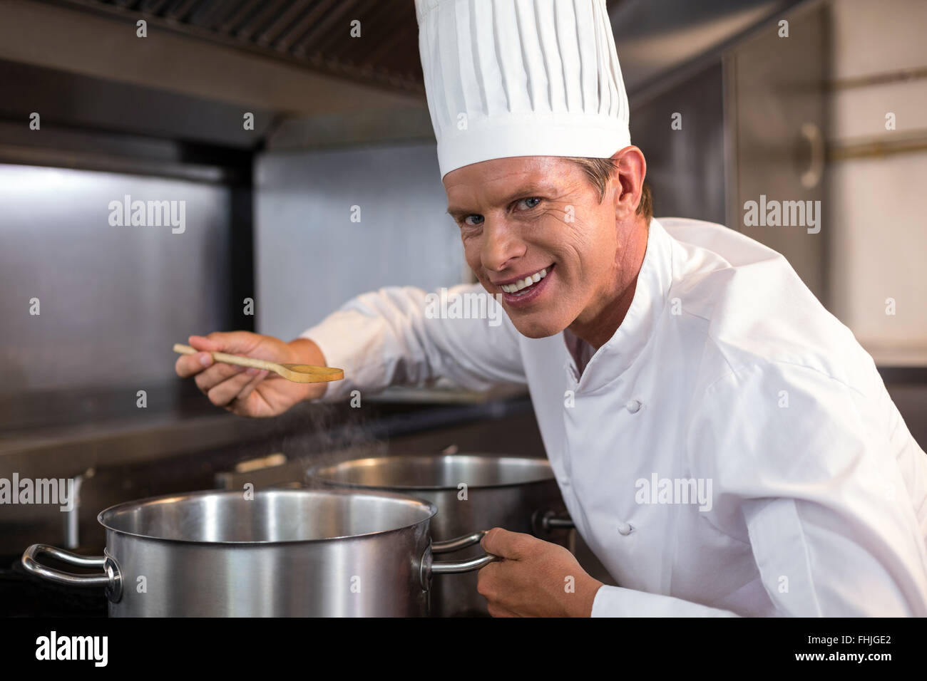 Happy chef tasting his dish Stock Photo - Alamy