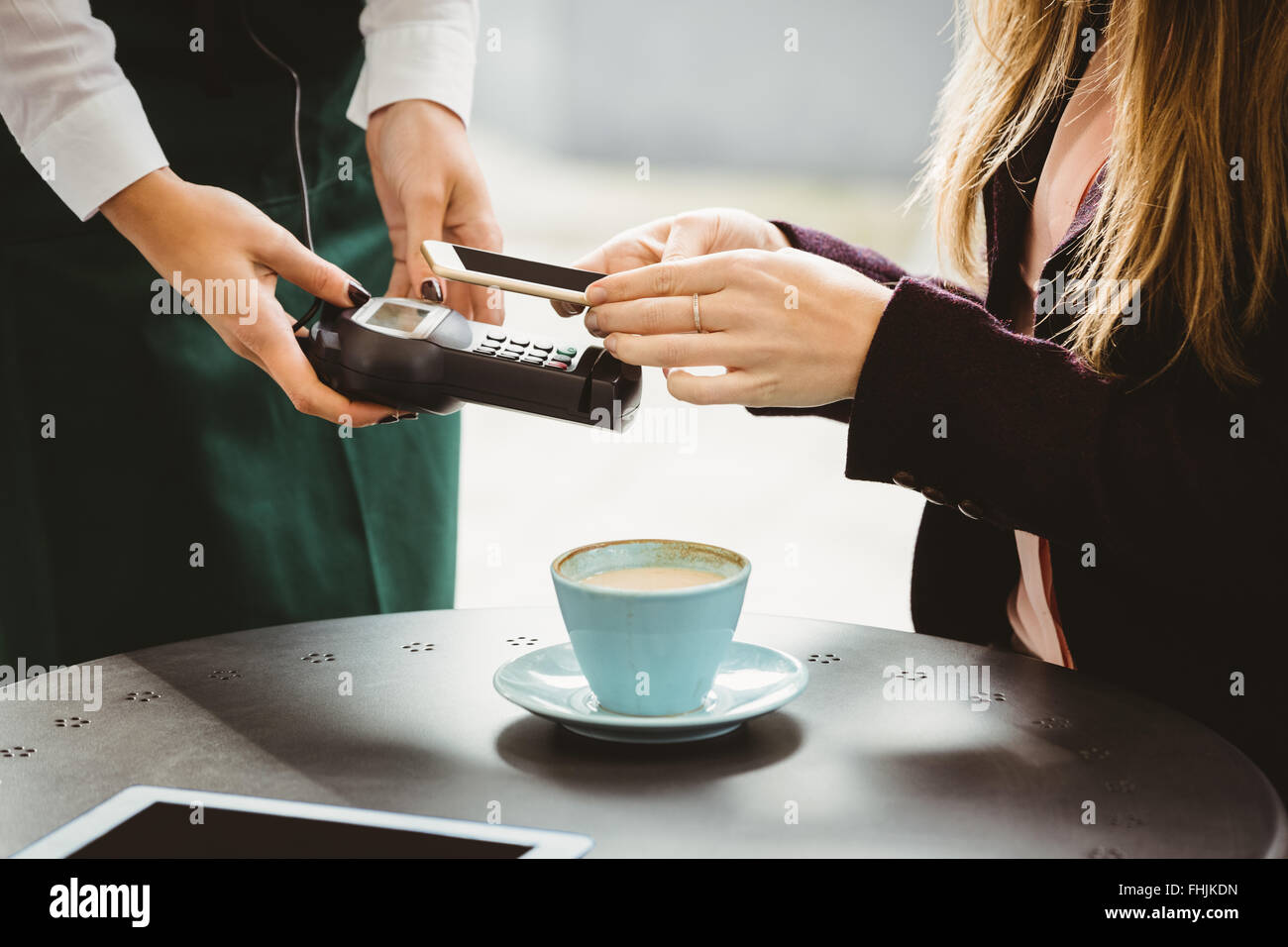 Woman paying with mobile phone Stock Photo - Alamy