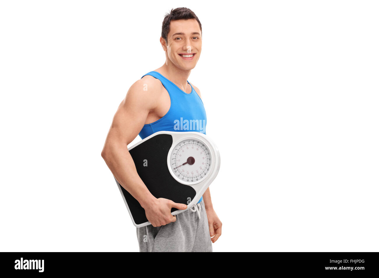 Young man in sportswear holding a weight scale and looking at the ...