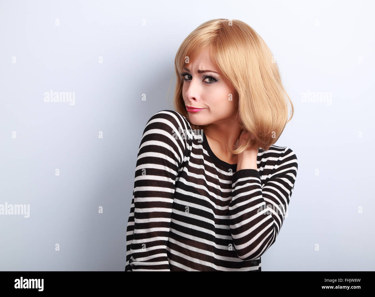 Displeased suspicious blond woman looking skeptical on blue background ...