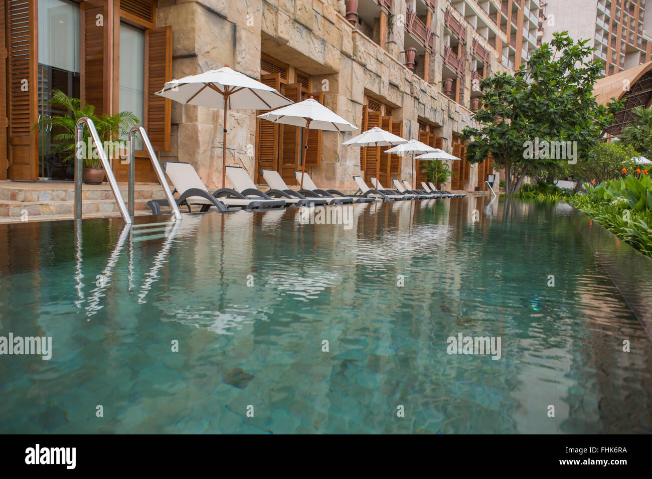 Swimming pool with stair and stone deck at hotel Stock Photo - Alamy