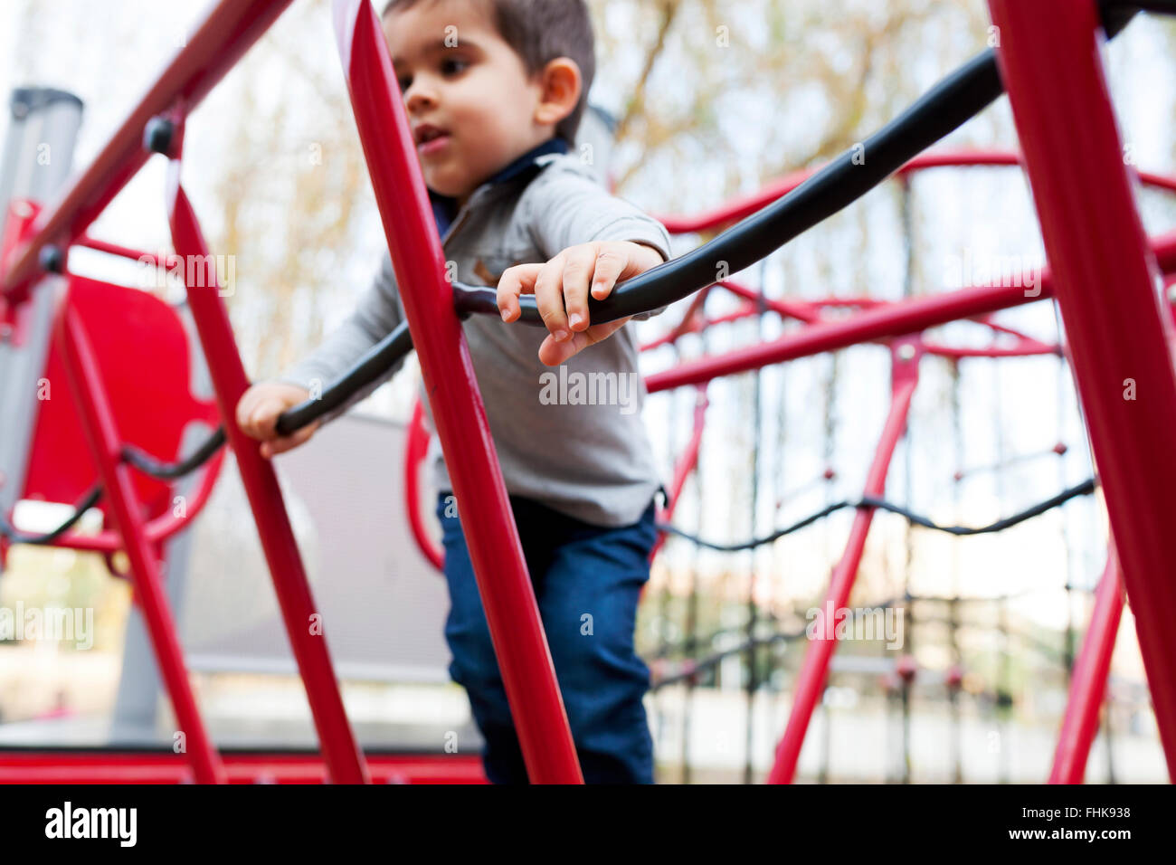 Toddler playing on red playground equipment Stock Photo - Alamy