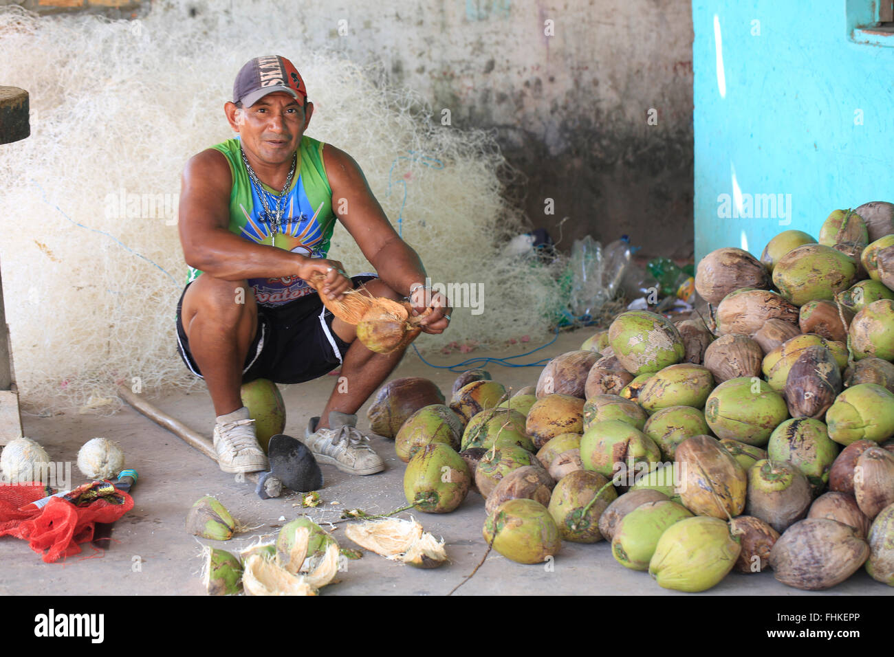 A man husking coconuts Stock Photo - Alamy