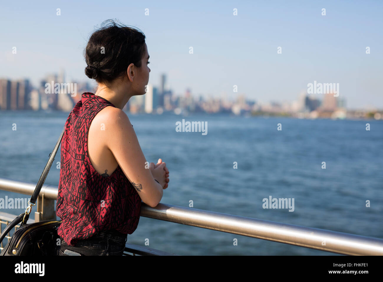 USA, New York City, Williamsburg, young woman leaning on a railing ...