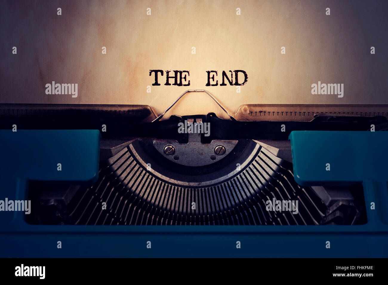 closeup of a blue retro typewriter and the text the end written with it ...