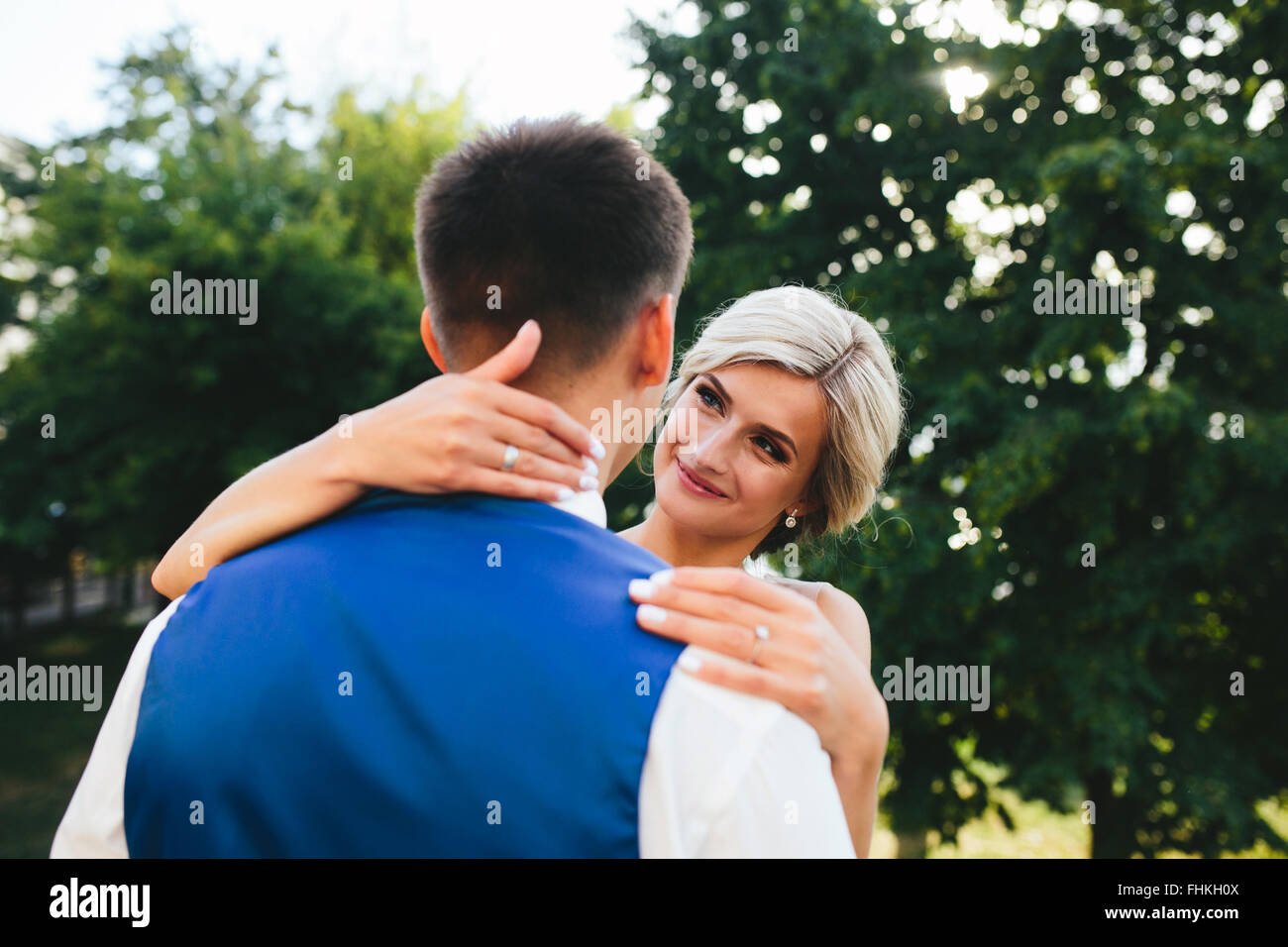 Beautiful wedding couple hugging in the park Stock Photo - Alamy