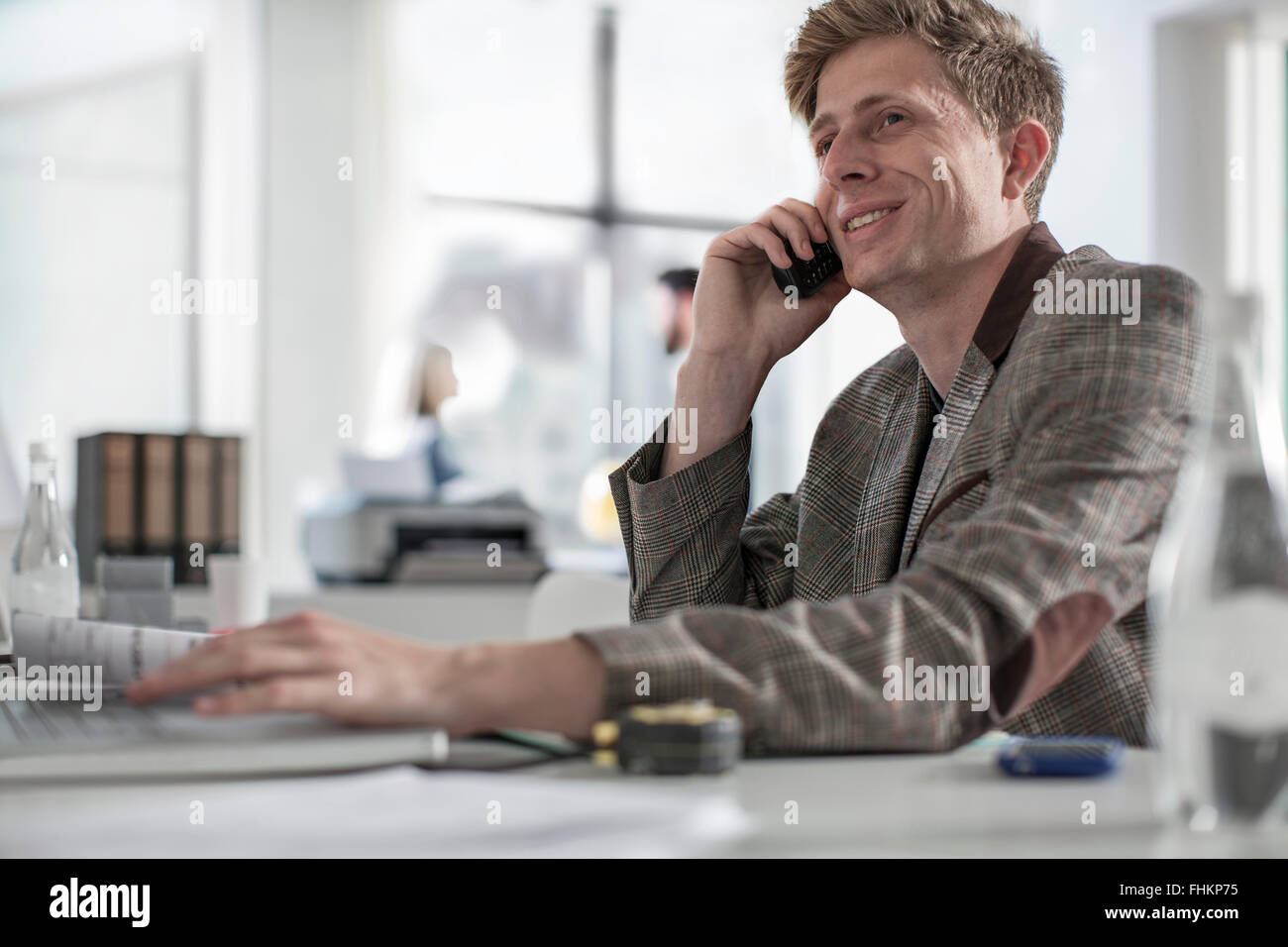 Man in office at desk talking on phone Stock Photo - Alamy