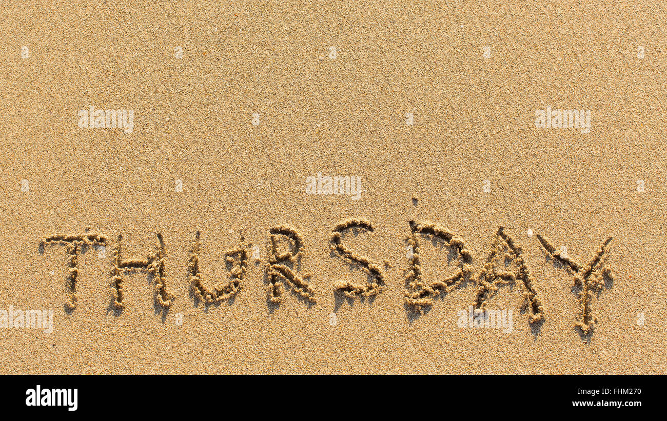 Thursday - word drawn on the bright yellow beach sand Stock Photo - Alamy