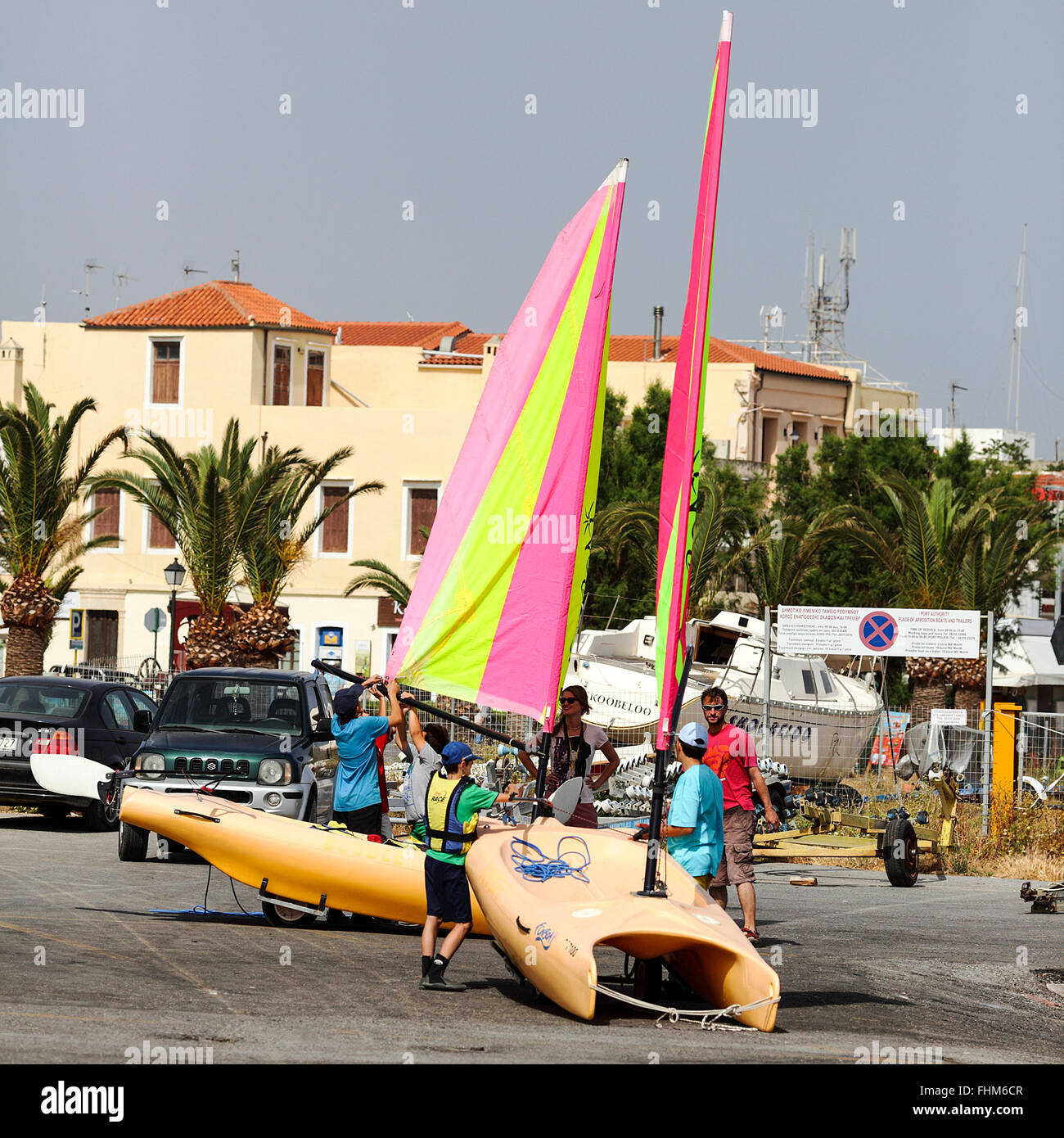 Young family and friends prepping small sailing dinghies for a piece of ...