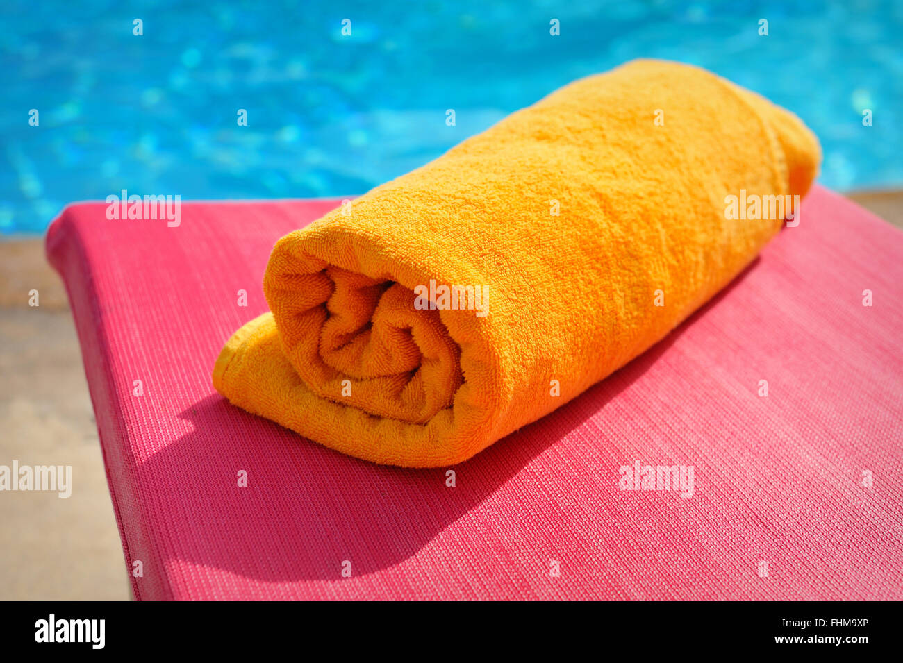 folded orange towel on the background of the pool Stock Photo - Alamy