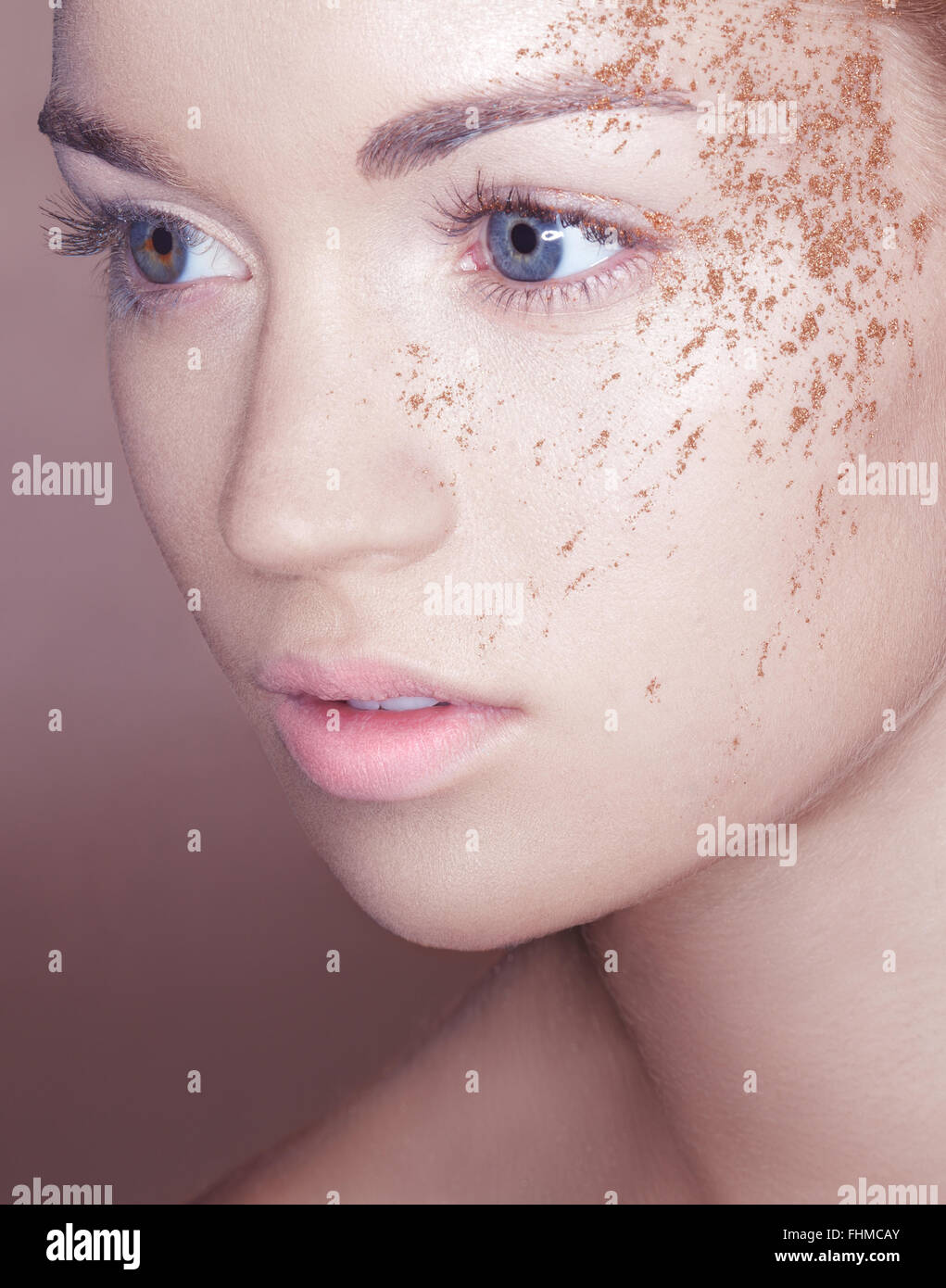 A woman with gold makeup powder on her face Stock Photo - Alamy