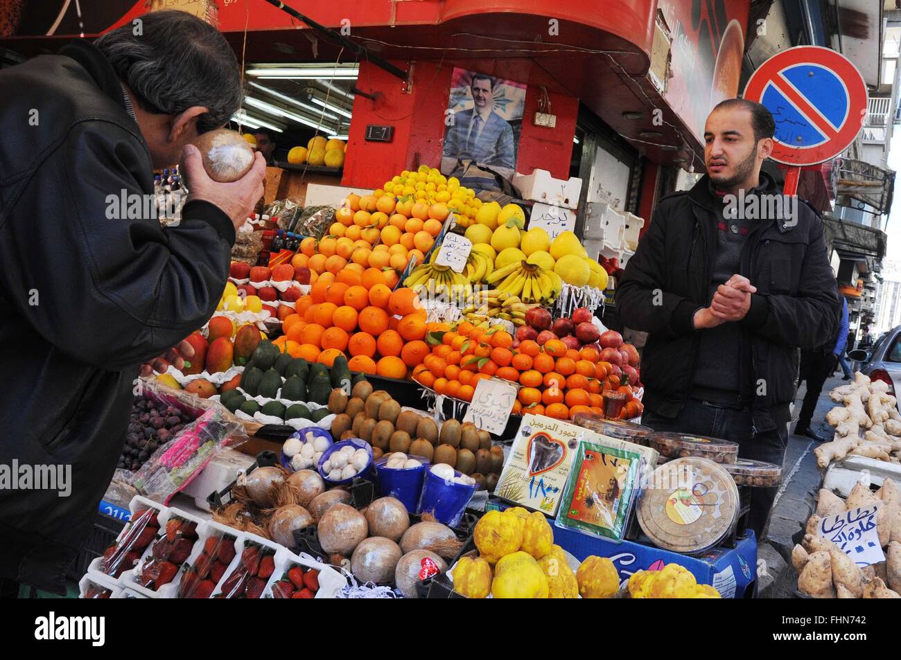 Damascus. 25th Feb, 2016. A Syrian man buys fruit and vegetable from a ...