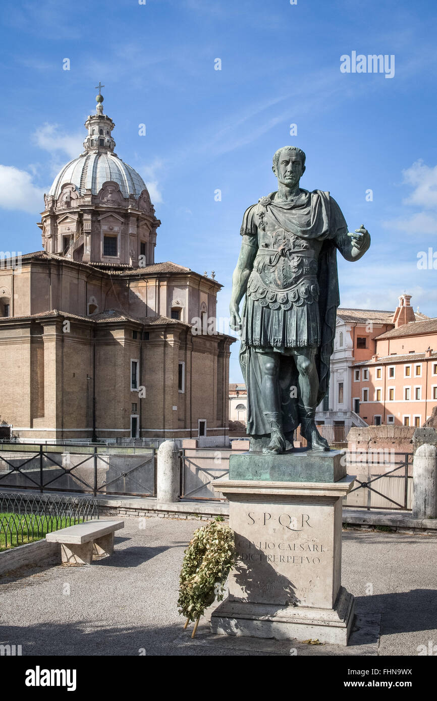 Julius Caesar statue with a wreath at its base and chapel dome and blue ...