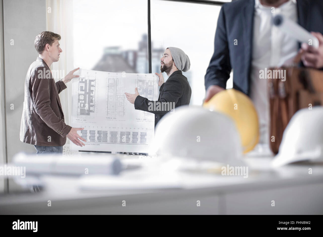 Two men discussing construction plan at the window Stock Photo - Alamy