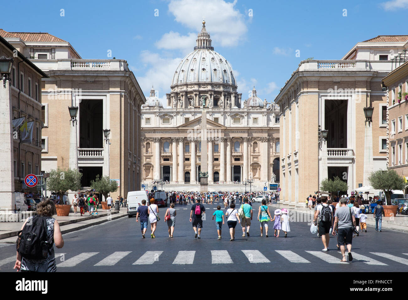Tourists approach St. Peter's Square in Vatican City. Vatican City is a ...