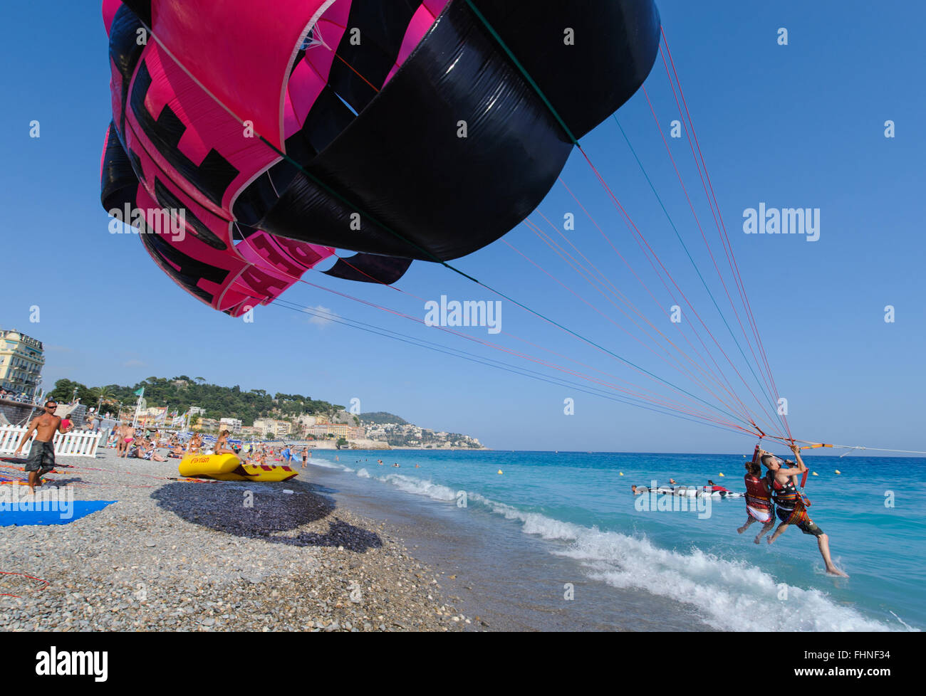 Two people paragliding from the beach at Nice Stock Photo - Alamy