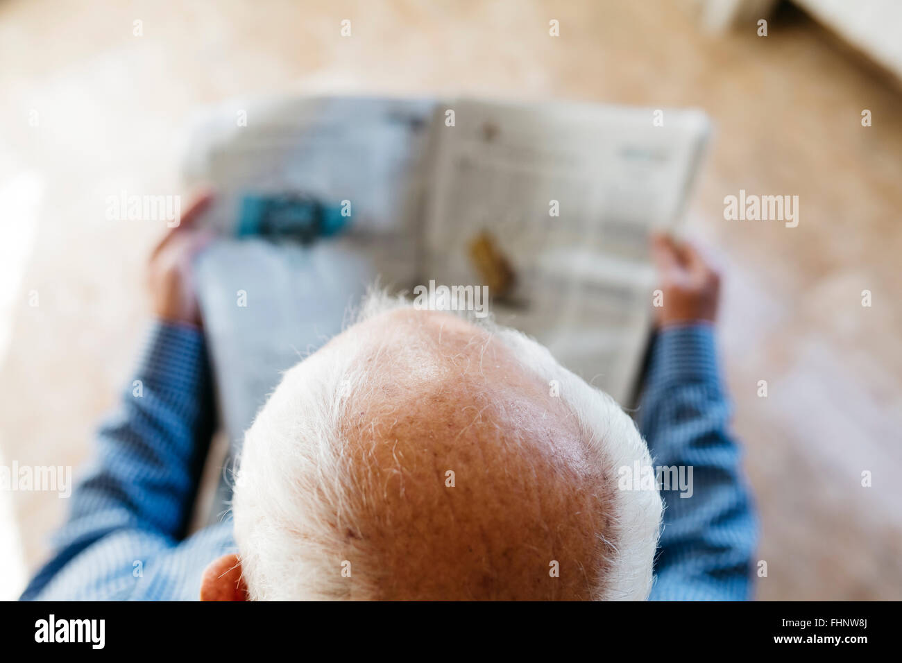 Head of senior man reading newspaper at home, top view Stock Photo - Alamy