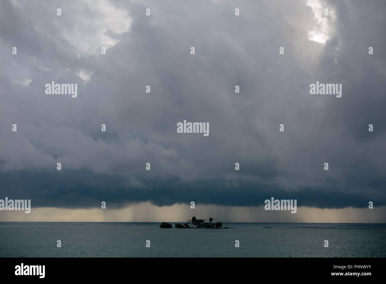 Rain and storm clouds over a tiny island in the ocean Stock Photo - Alamy