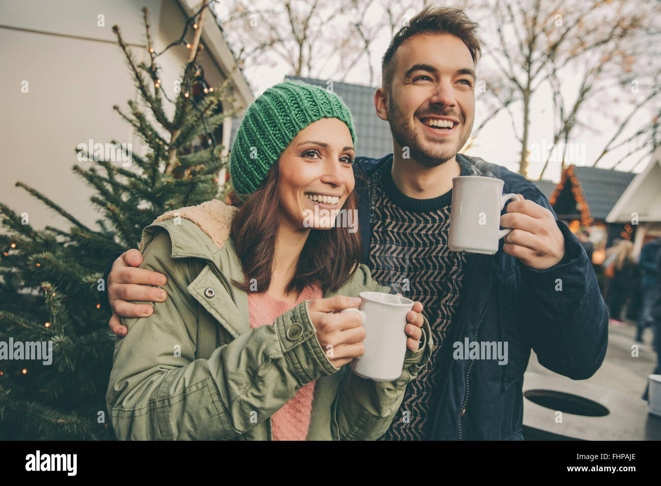 Couple having a hot punch on the Christmas Market Stock Photo - Alamy