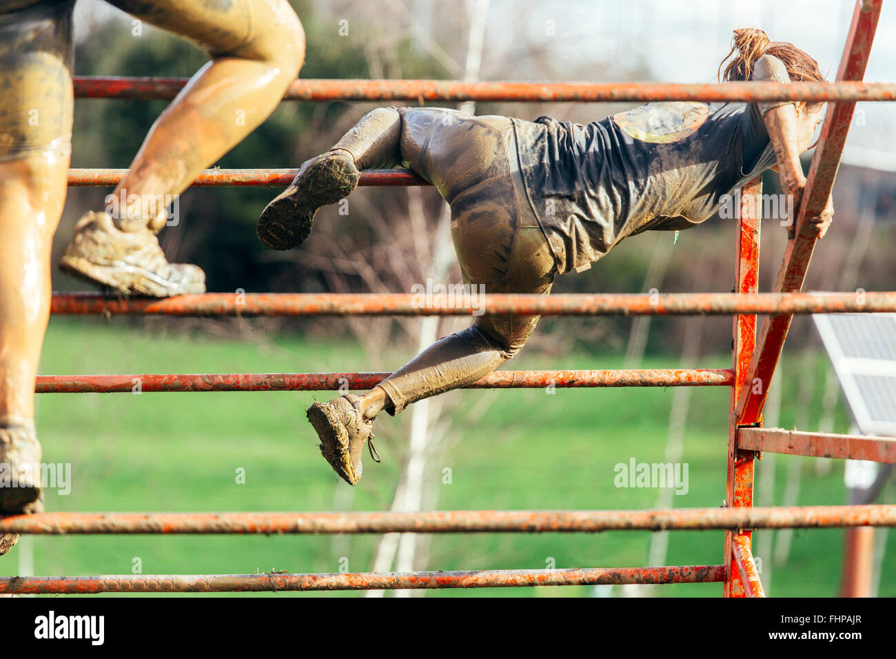 Participants in extreme obstacle race climbing over hurdle Stock Photo ...