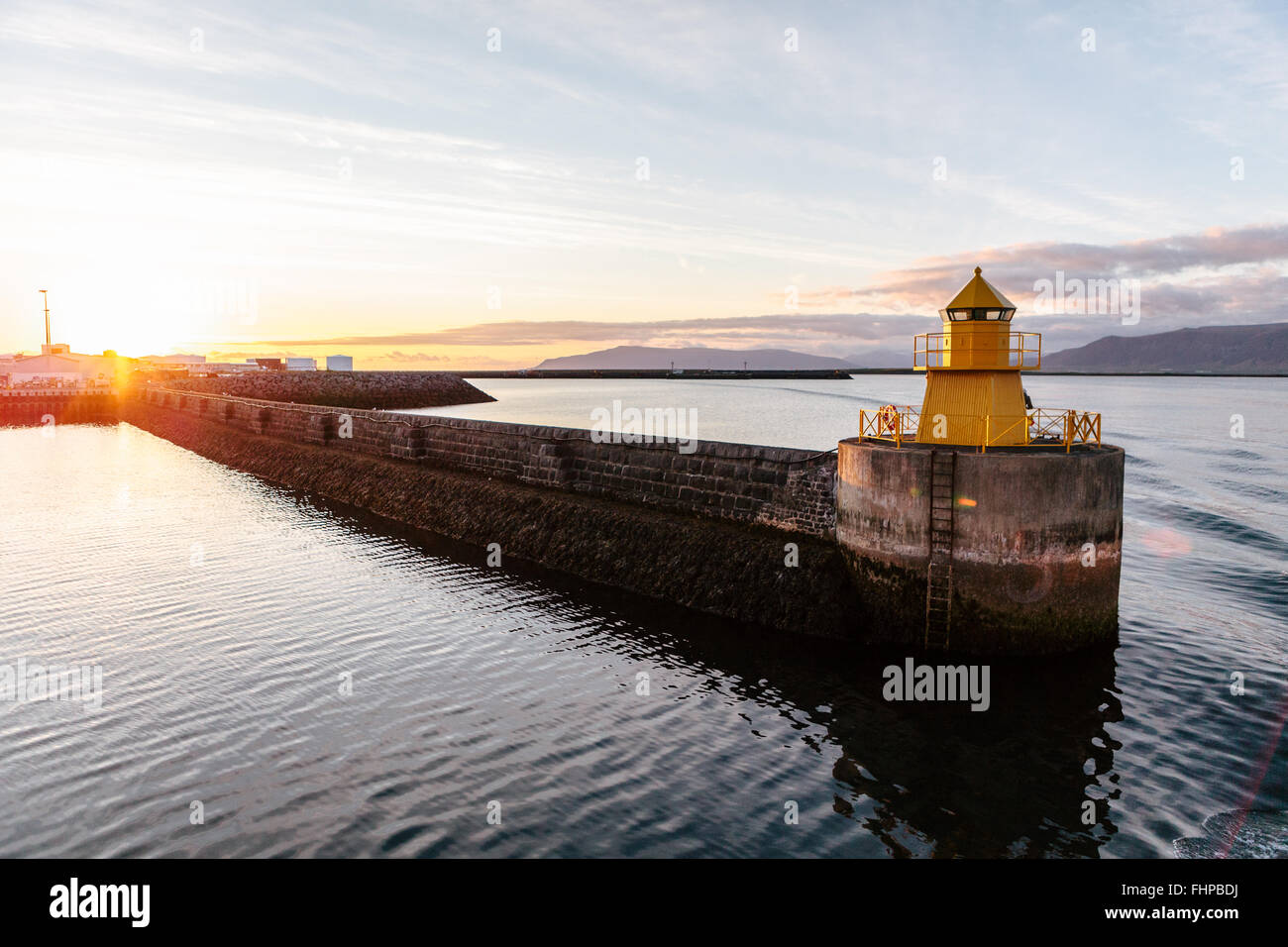 A yellow lighthouse in Reykjavik Harbour, Iceland at sunset Stock Photo ...