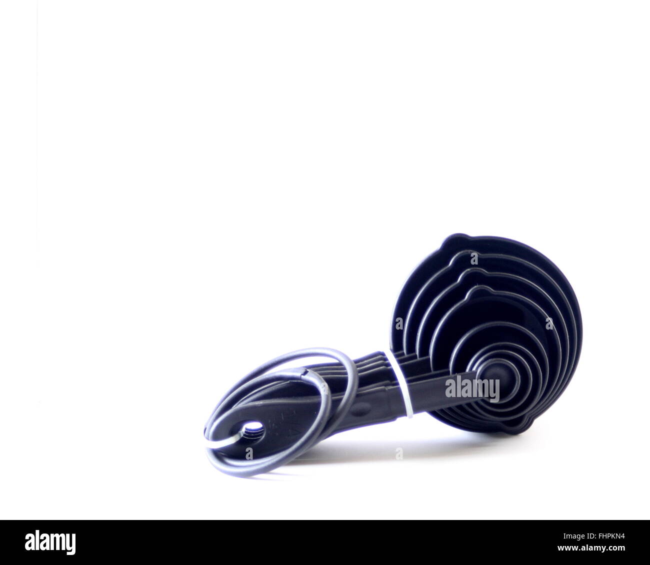 Nestled kitchen measuring cups and spoons on white Stock Photo - Alamy