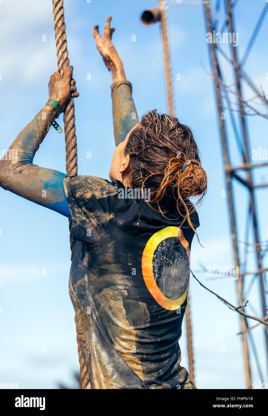 Participant in extreme obstacle race climbing up a rope Stock Photo - Alamy