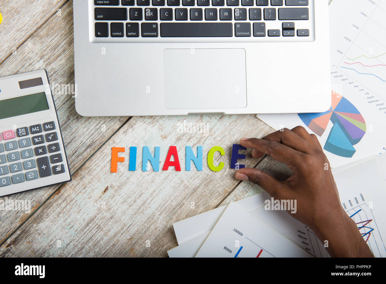 Hand arrange wood letters as finance word Stock Photo - Alamy