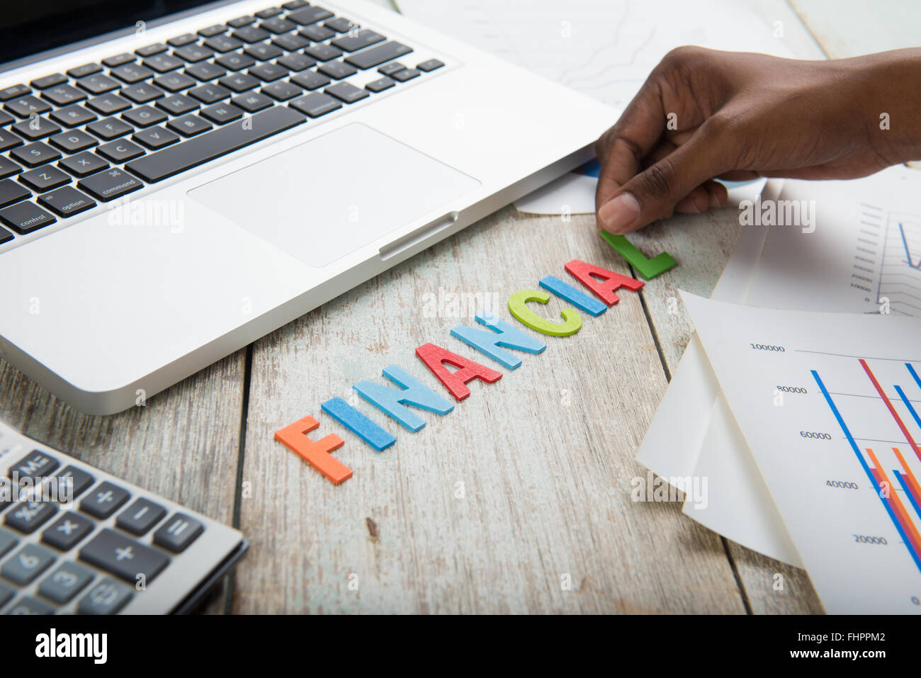 Hand arrange wood letters as financial word Stock Photo - Alamy