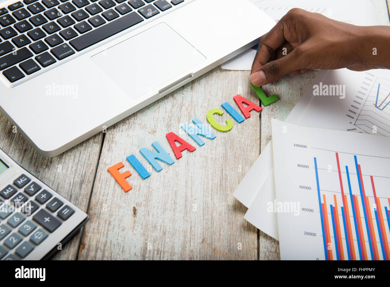 Hand arrange wood letters as financial word Stock Photo - Alamy