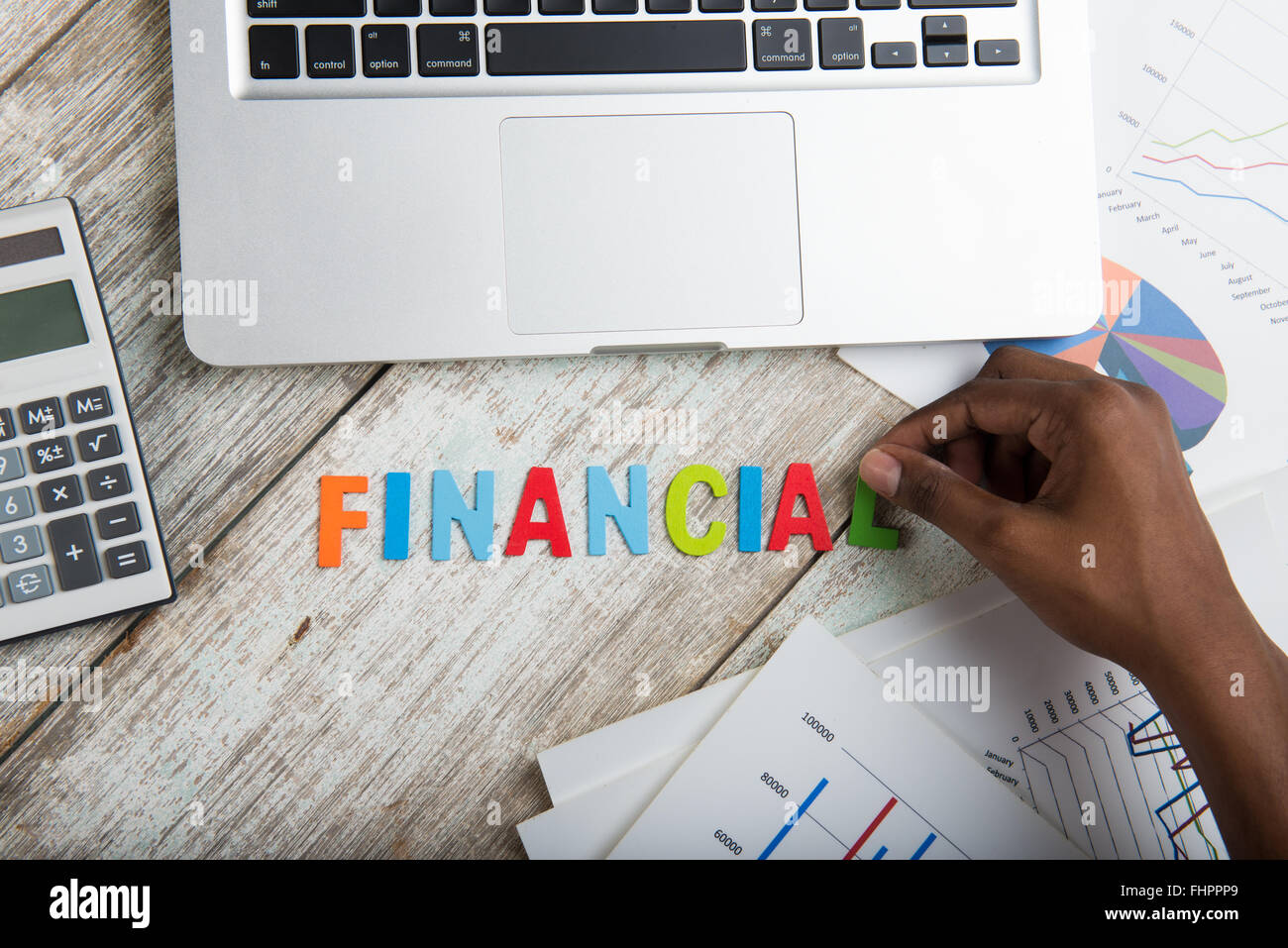 Hand arrange wood letters as financial word Stock Photo - Alamy