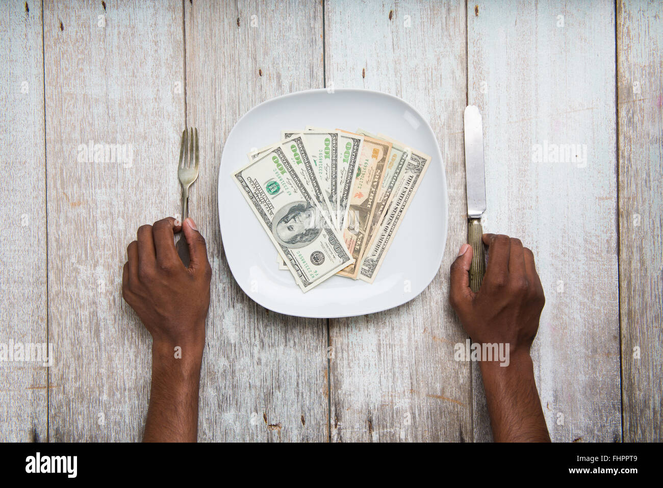 eating banknotes symbolising consumerism and corruption Stock Photo - Alamy