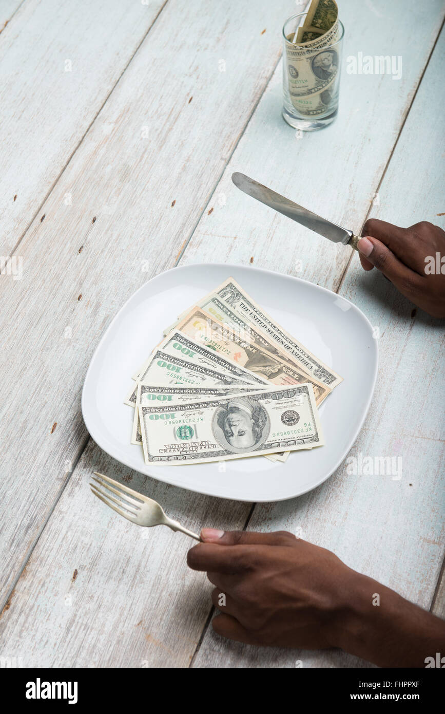 hand eating banknotes symbolising consumerism and corruption Stock ...