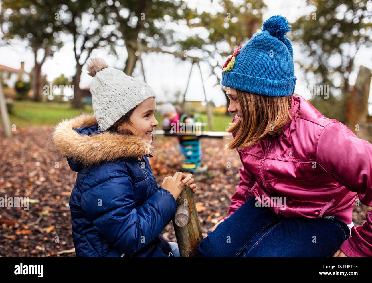 Two talking girls on a playground in autumn Stock Photo - Alamy