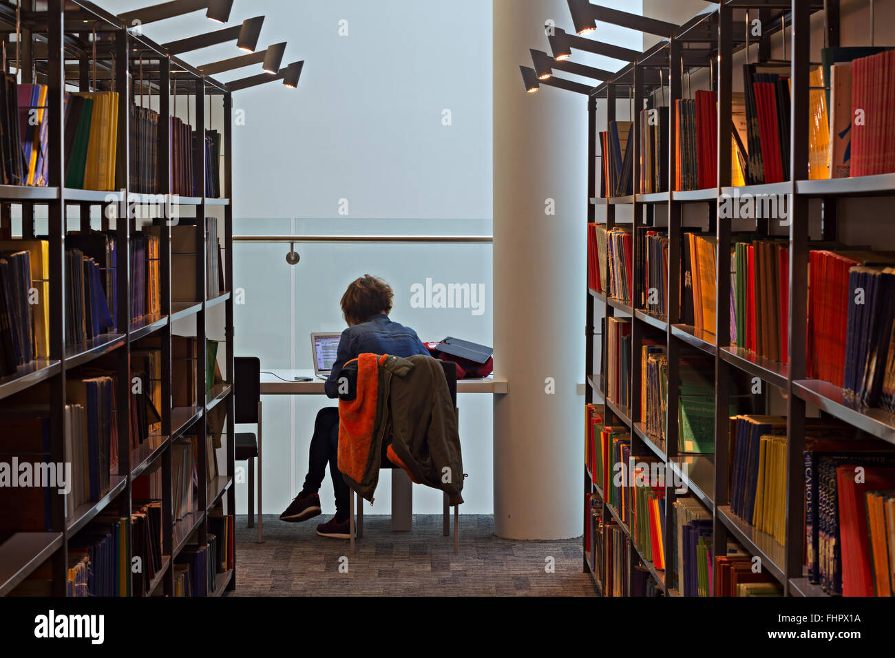 Blurred books and student studying in a library Stock Photo - Alamy