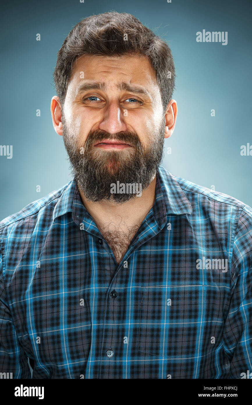 The crying man on face closeup on blue background Stock Photo - Alamy