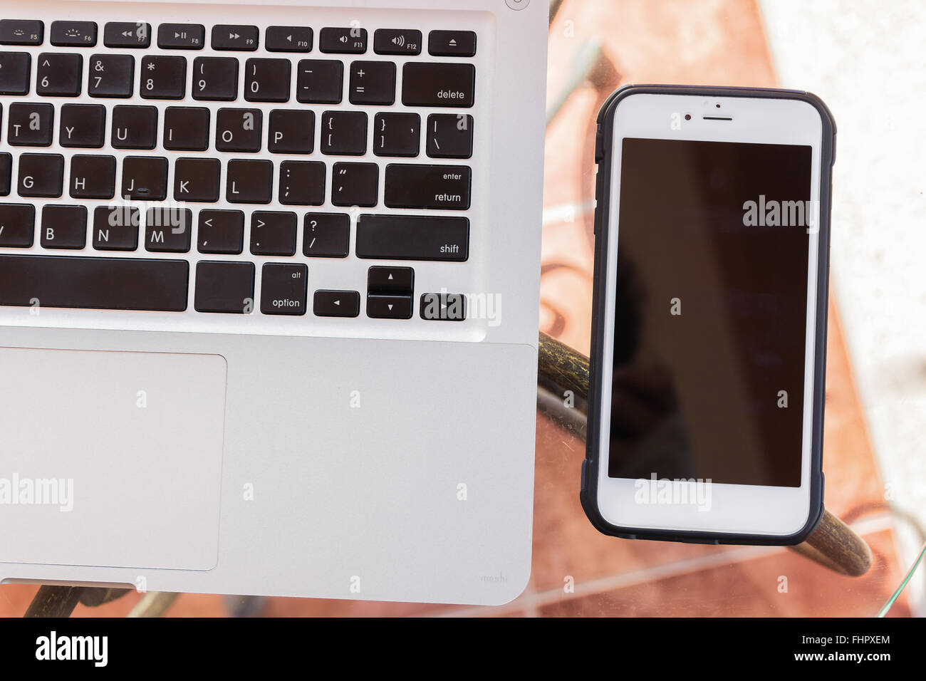 Laptop computer, phone ,books and plant on the table in swimming pool ...