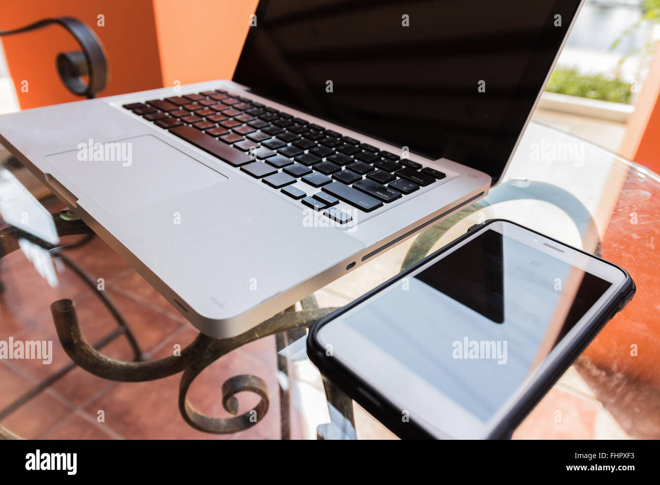 Laptop computer, phone ,books and plant on the table in swimming pool ...