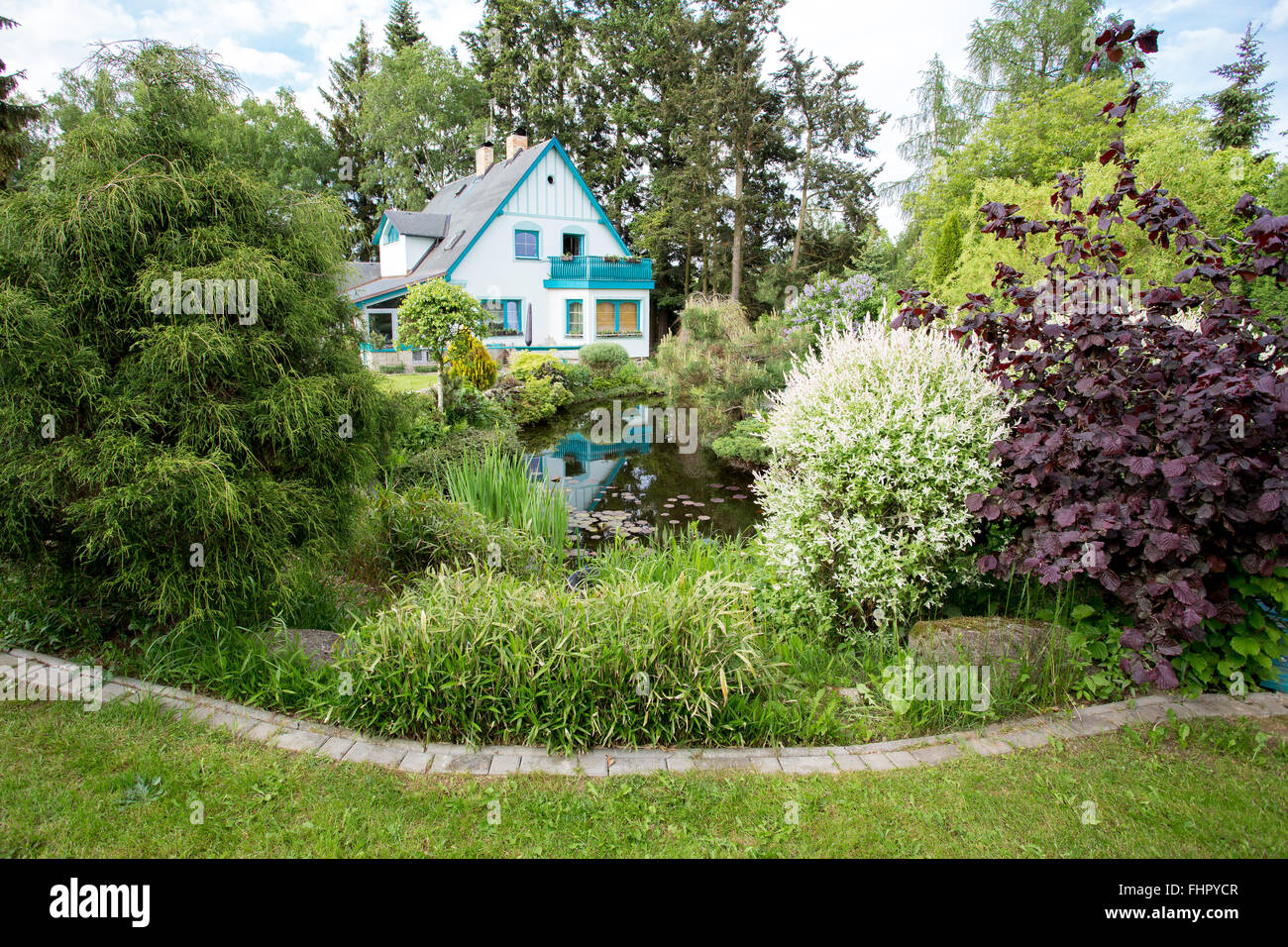 Beautiful luxury house situated in in spring garden, with conifers ...