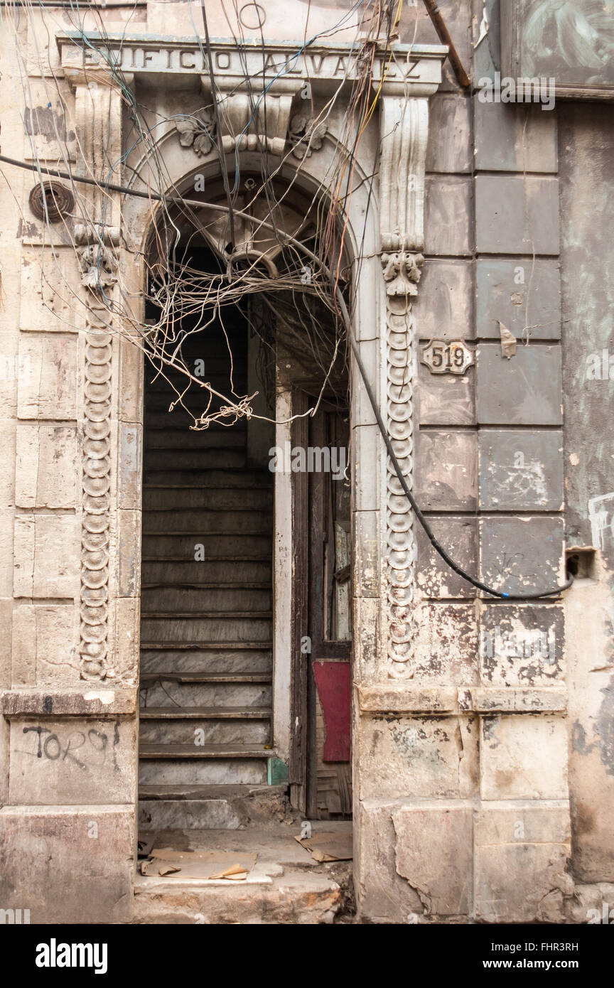 A tangle of hanging electrical wires above a doorway of a building in ...
