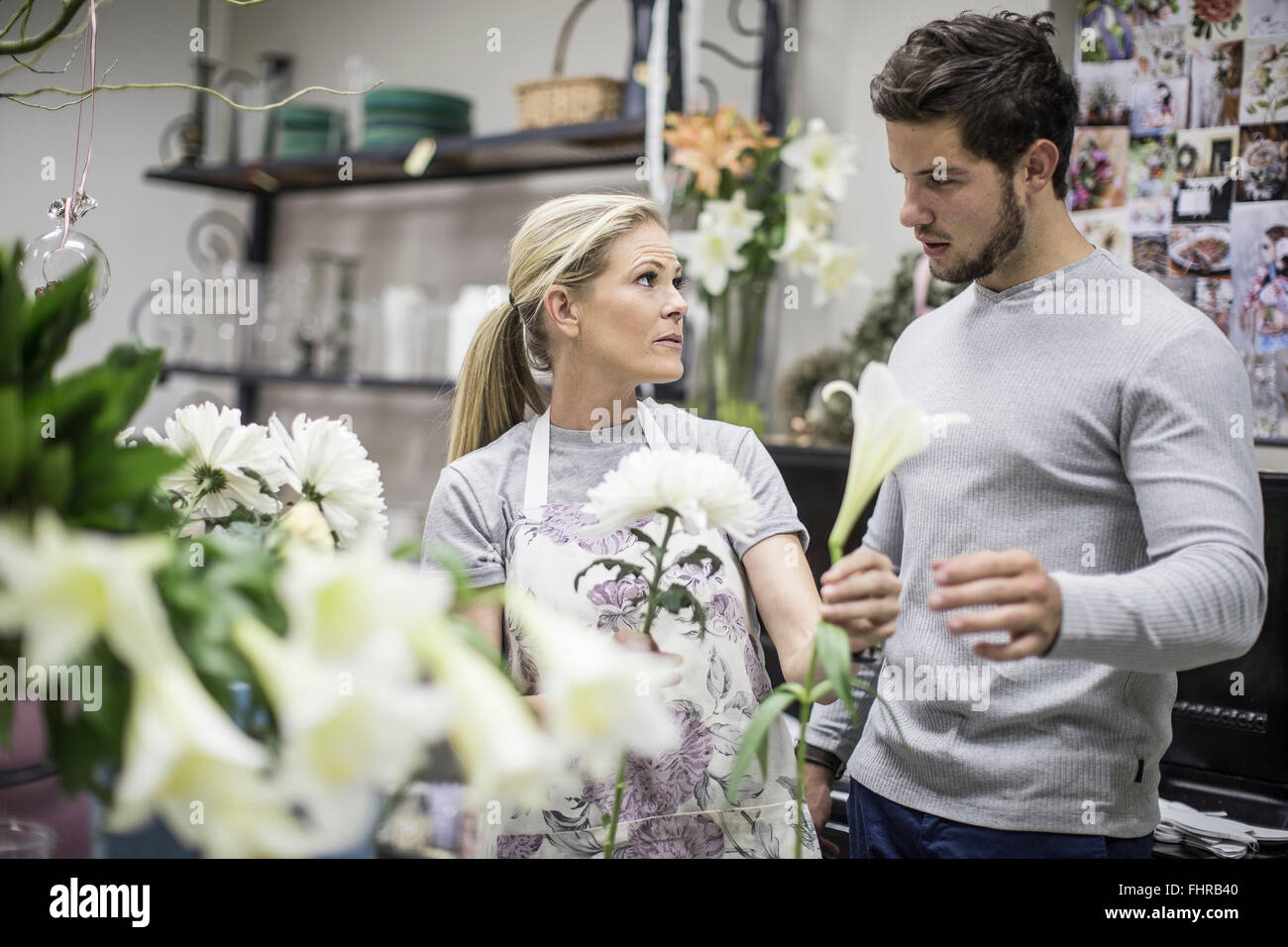 Shop assistant in flower shop advising customer Stock Photo - Alamy