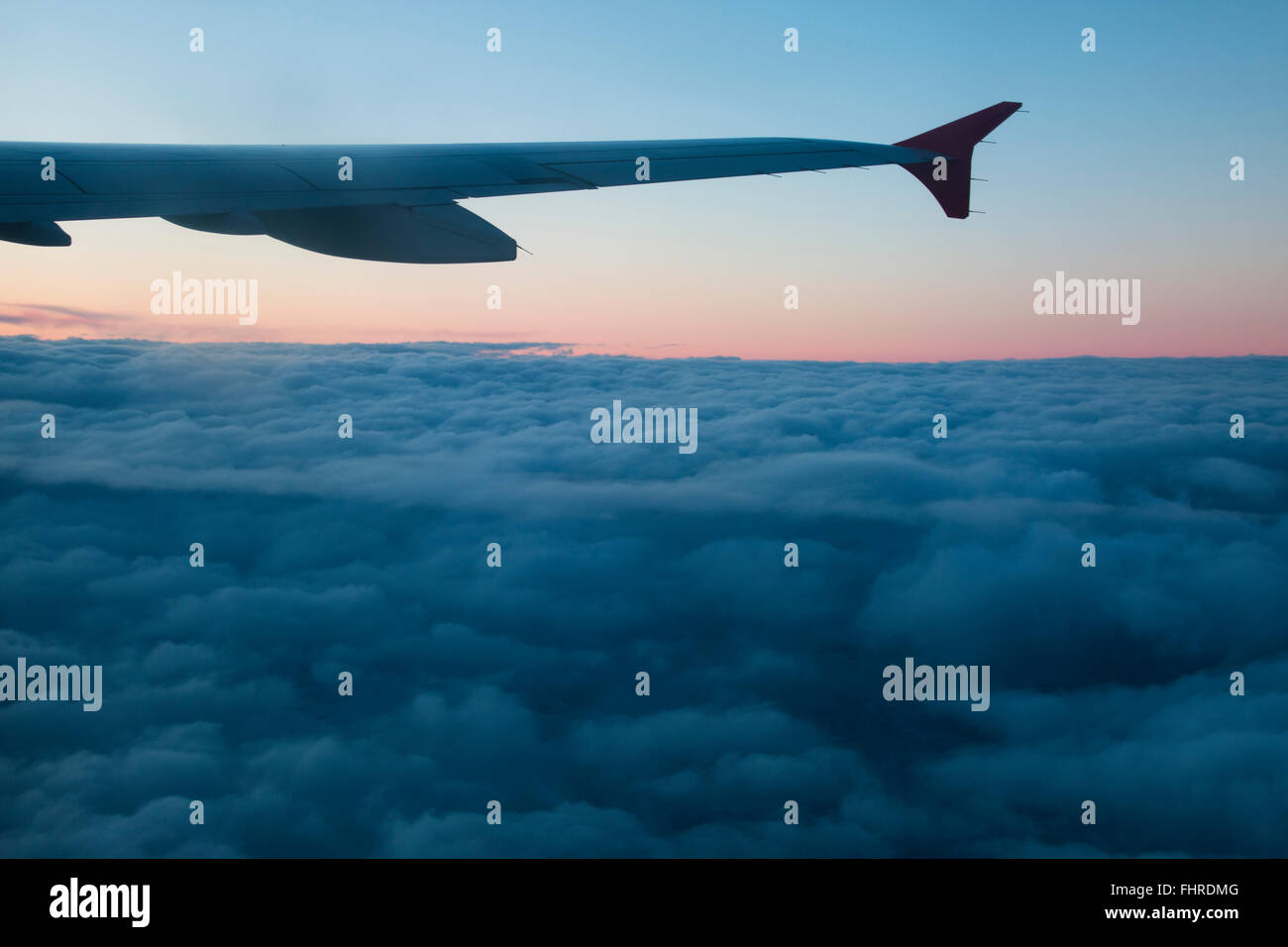 White and red wing of a Turkish Airlines airplane flying above the dark ...