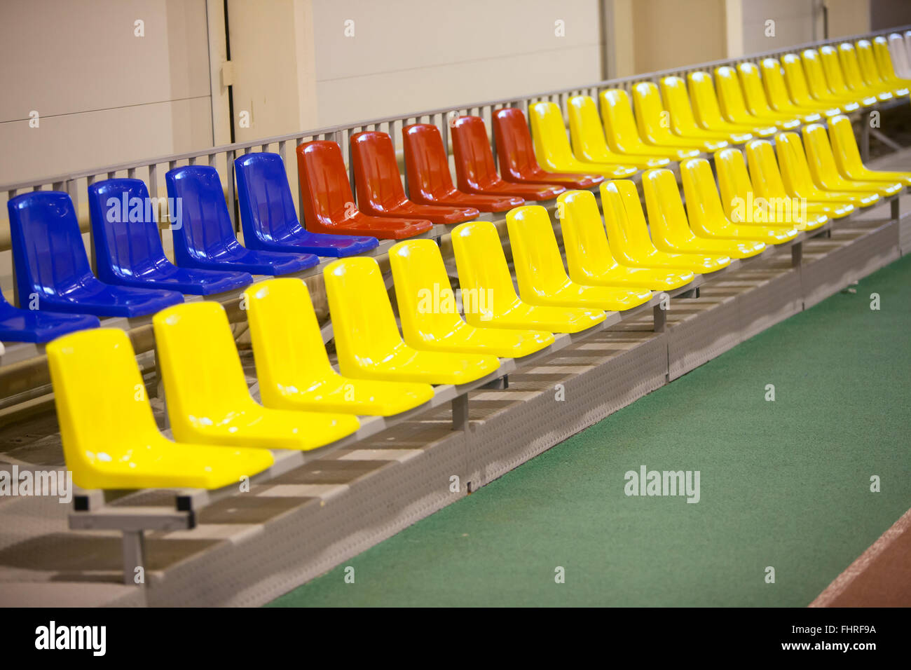 Colored seats at a stadium in the room Stock Photo - Alamy