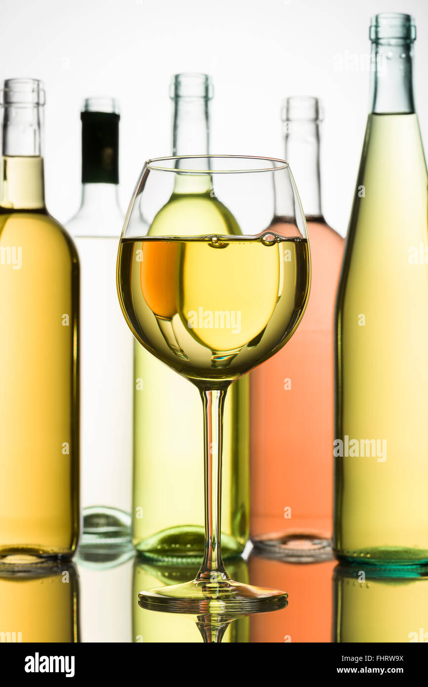 goblet with white wine and bottles on background Stock Photo - Alamy