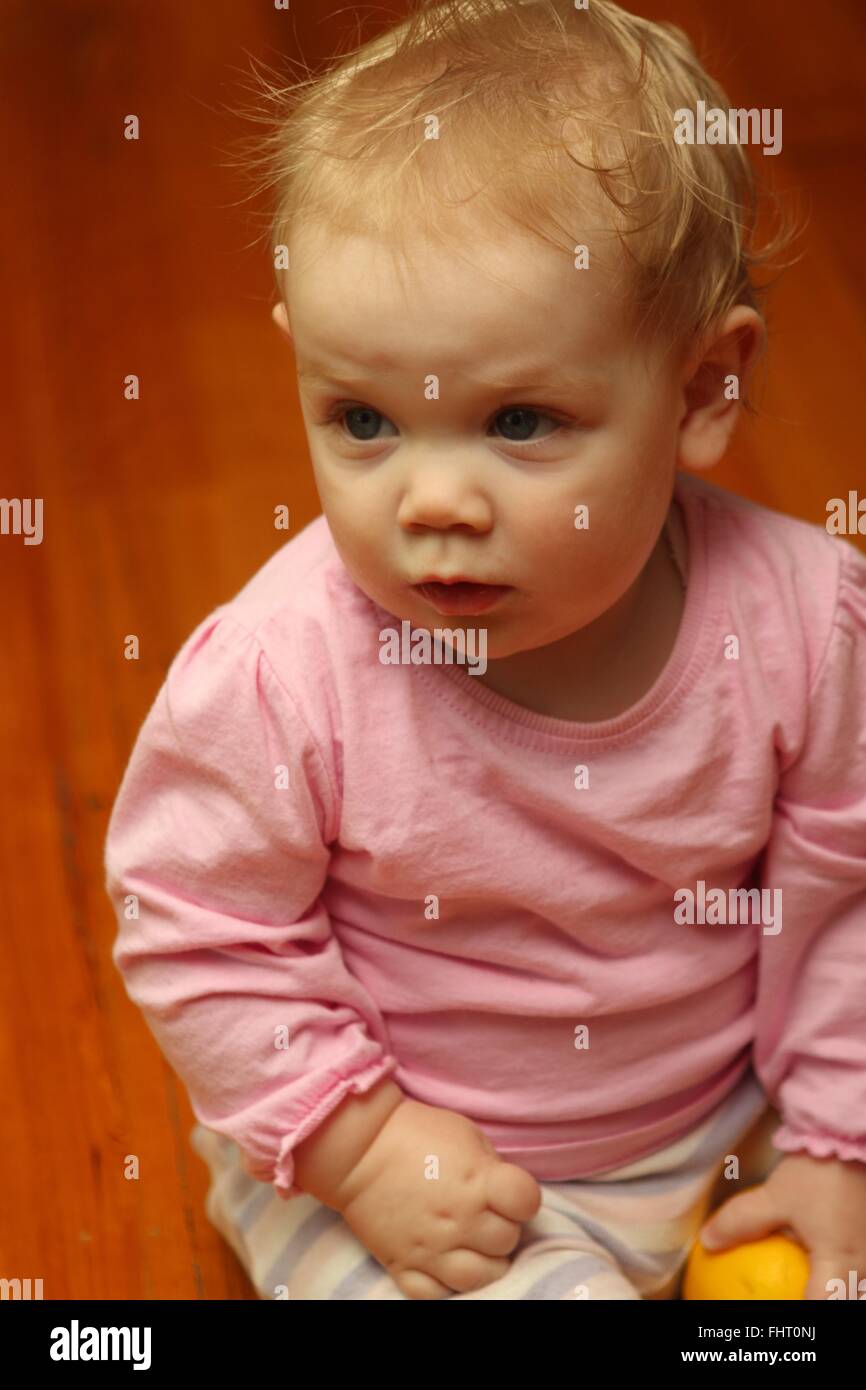 A small baby girl playing by herself Stock Photo - Alamy