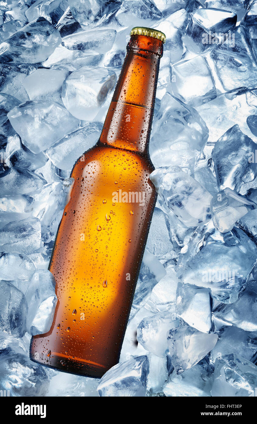Cold bottle of beer in the ice cubes. There is condensed moisture over ...