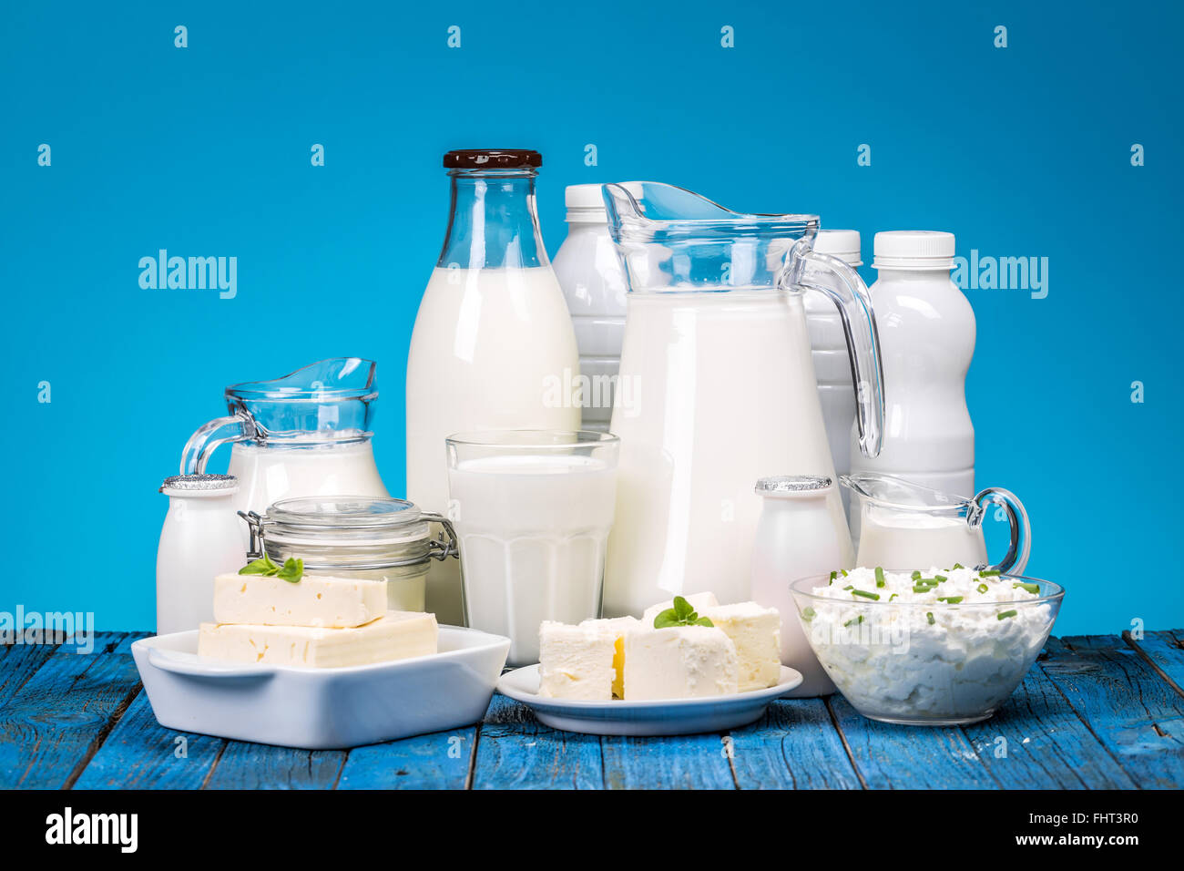 Dairy products on painted wooden table over blue background Stock Photo ...