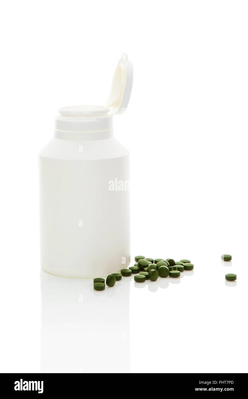 Pill container and green pills Stock Photo - Alamy